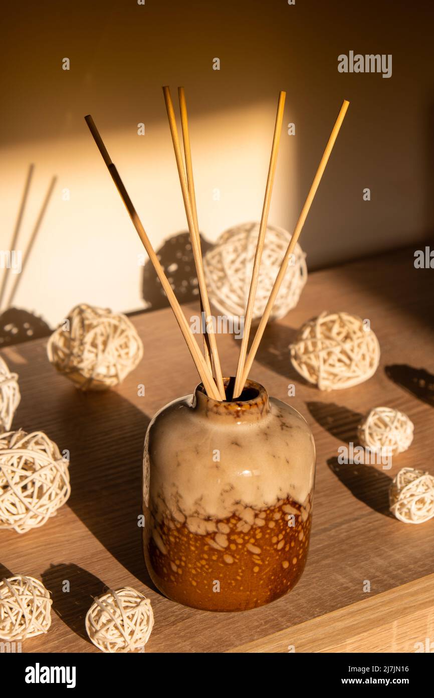 Cozy home decorations aroma reed diffuser in the living room. Home comfort concept. Bottle ...