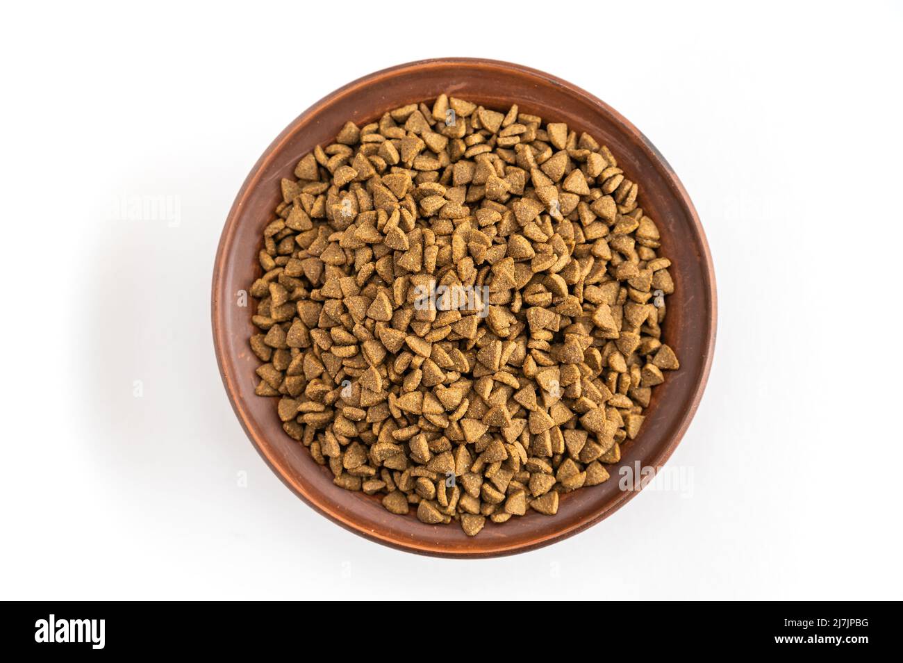 Pet food. Dry pelleted food in a brown clay bowl against a white ...
