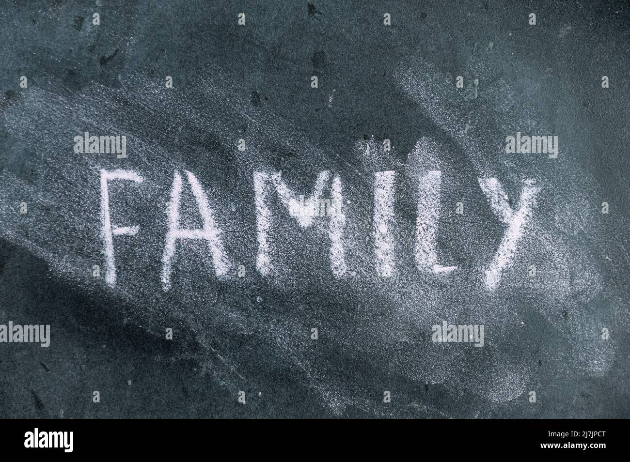 The semi-erased word FAMILY on the black chalkboard. Handwritten word ...