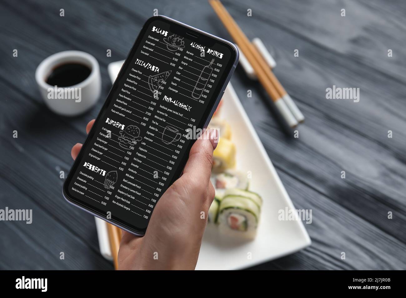 Young woman reading menu on screen of mobile phone, closeup Stock Photo ...