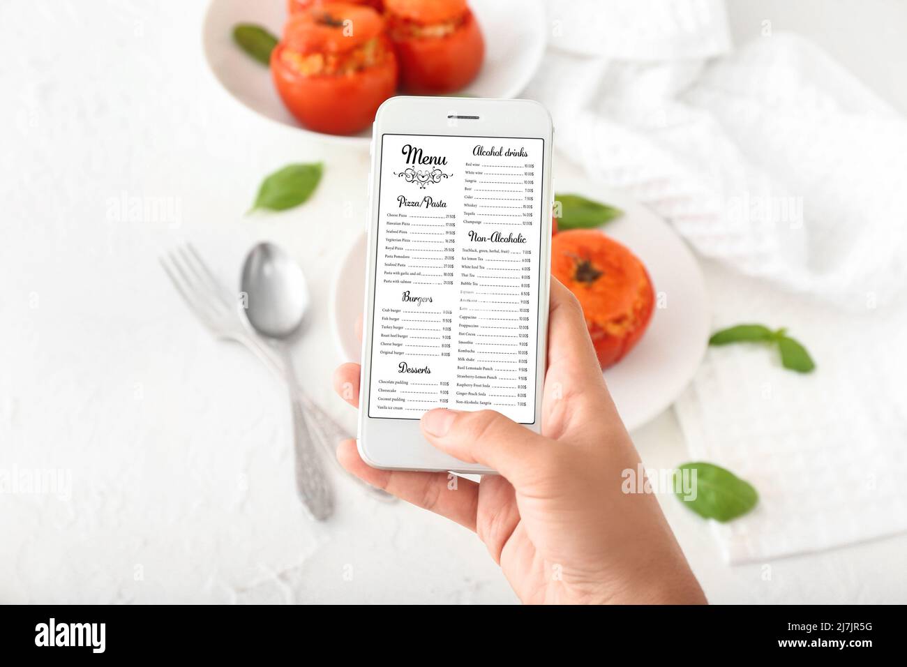 Young woman reading menu on screen of mobile phone, closeup Stock Photo ...