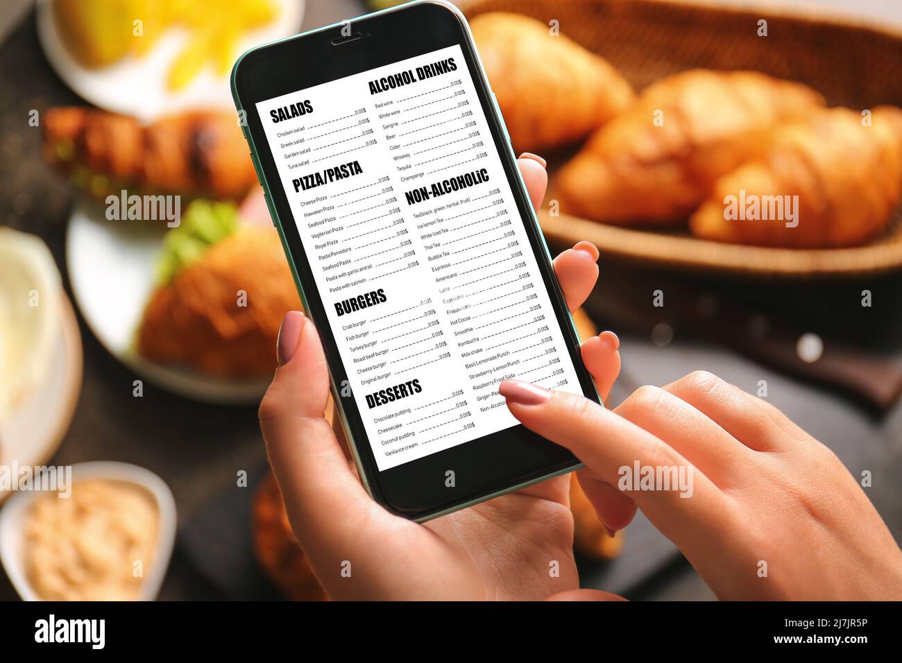 Young woman reading menu on screen of mobile phone, closeup Stock Photo ...