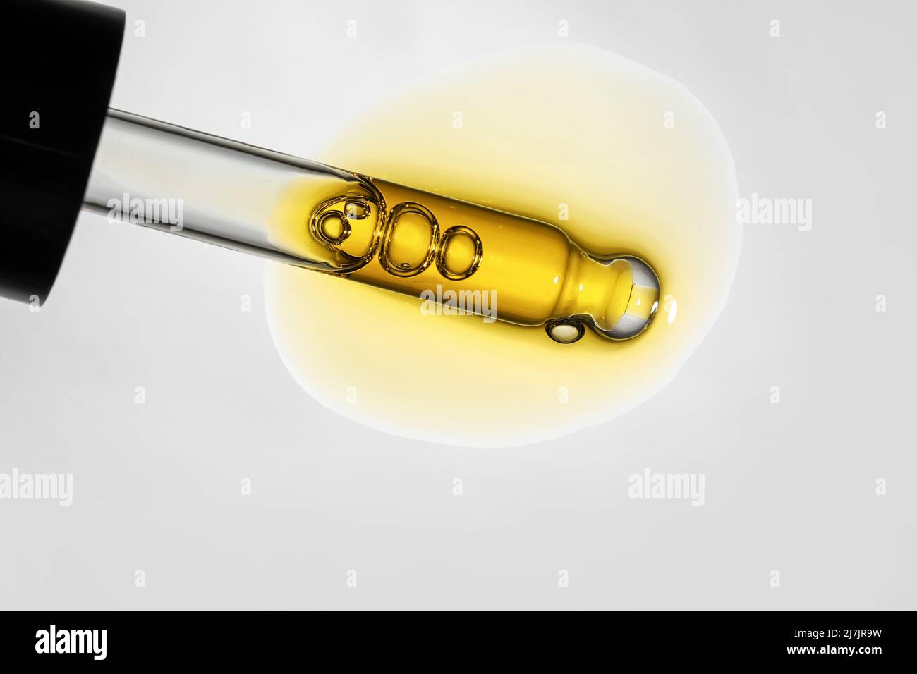 Essential oil and pipette on light background Stock Photo - Alamy