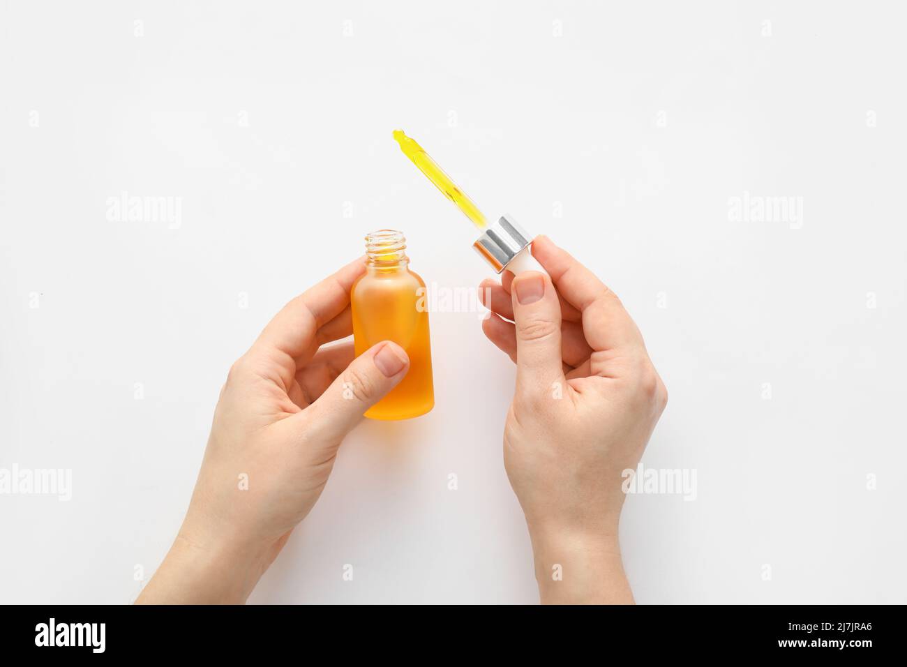 Woman holding bottle of essential oil on white background Stock Photo ...