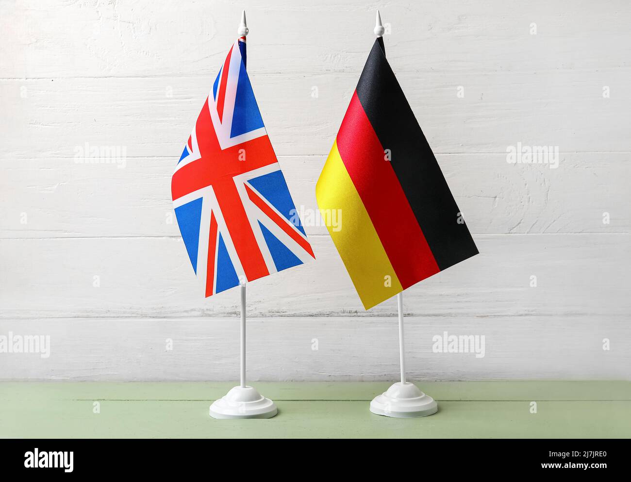 Flags of Great Britain and Germany on table against white wooden ...