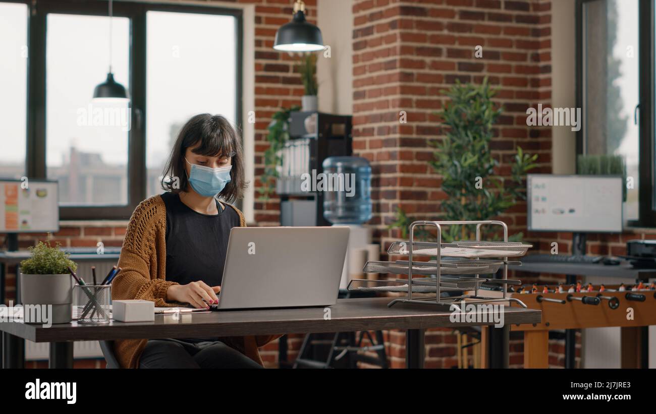 Business woman putting laptop at desk and working on project ...