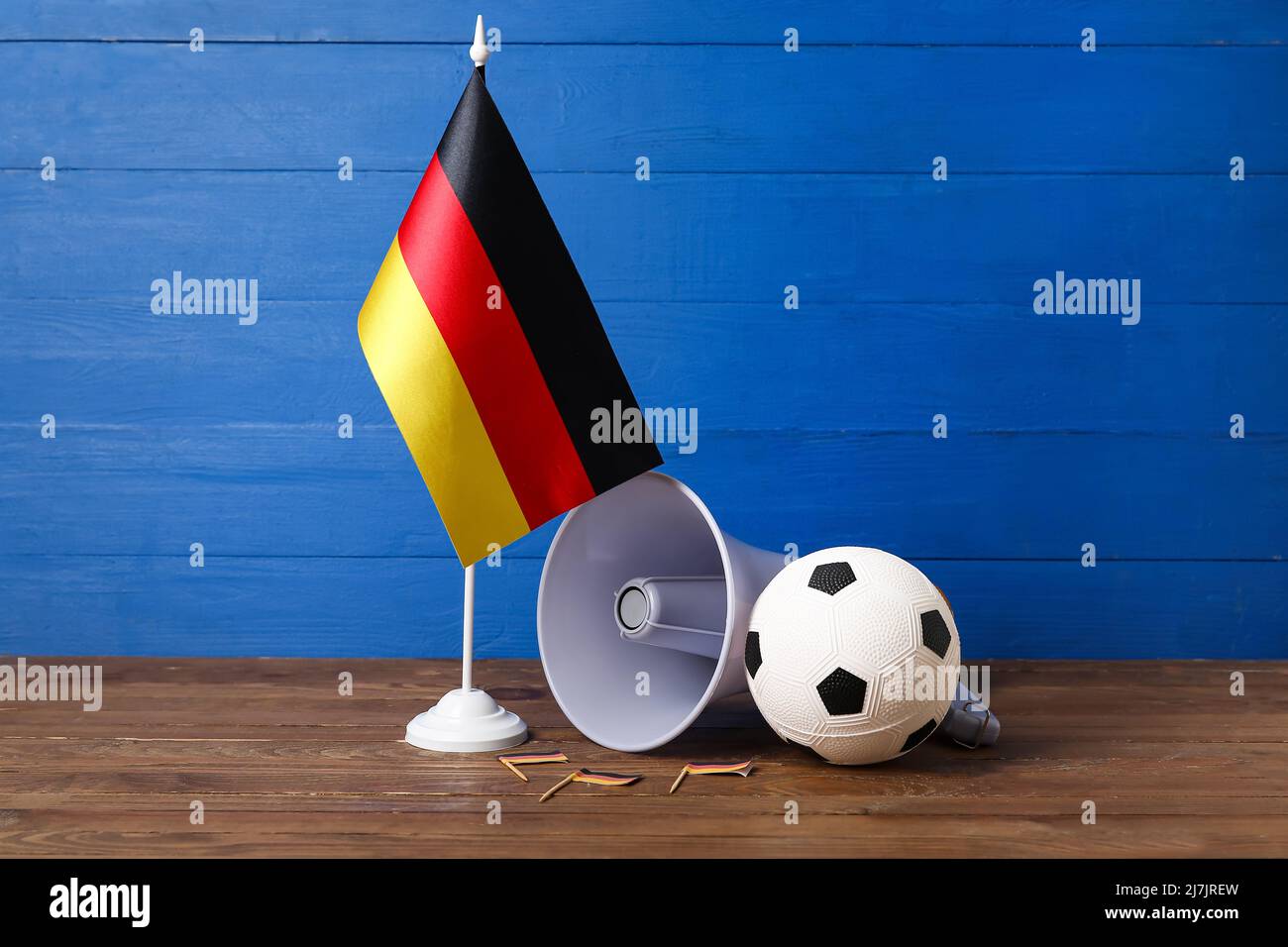 Flag of Germany, soccer ball and bullhorn on color wooden background ...