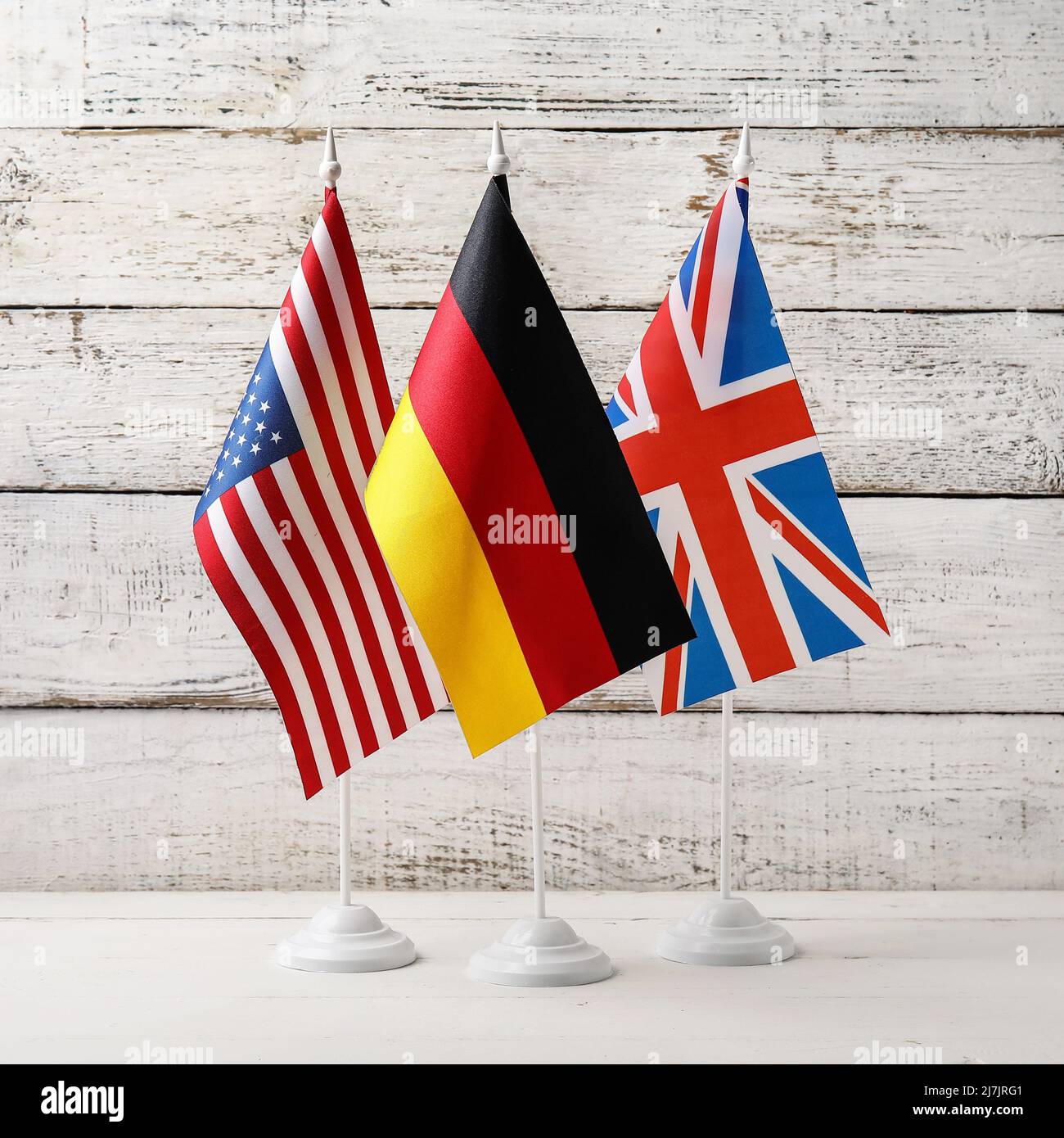 Flags of USA, Germany and Great Britain on table against light wooden ...