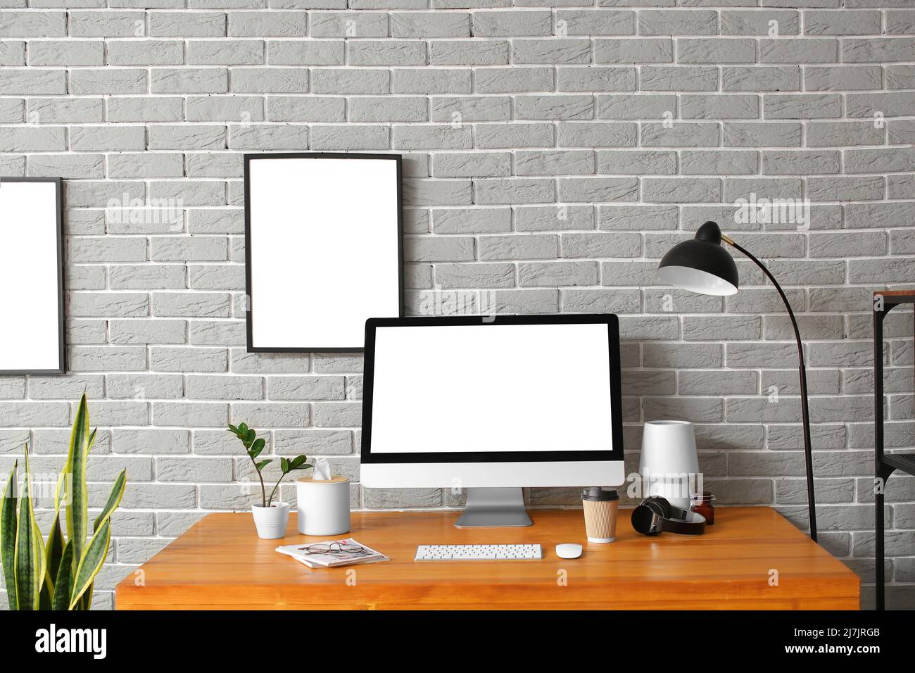 Workplace with modern computer near grey brick wall Stock Photo - Alamy