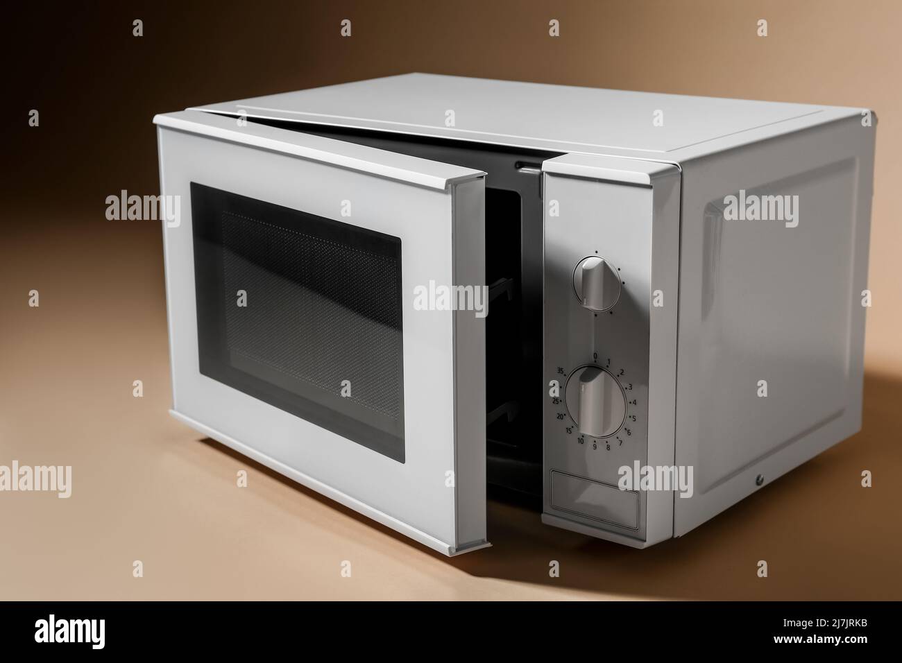 White microwave oven with opened door on beige background Stock Photo ...