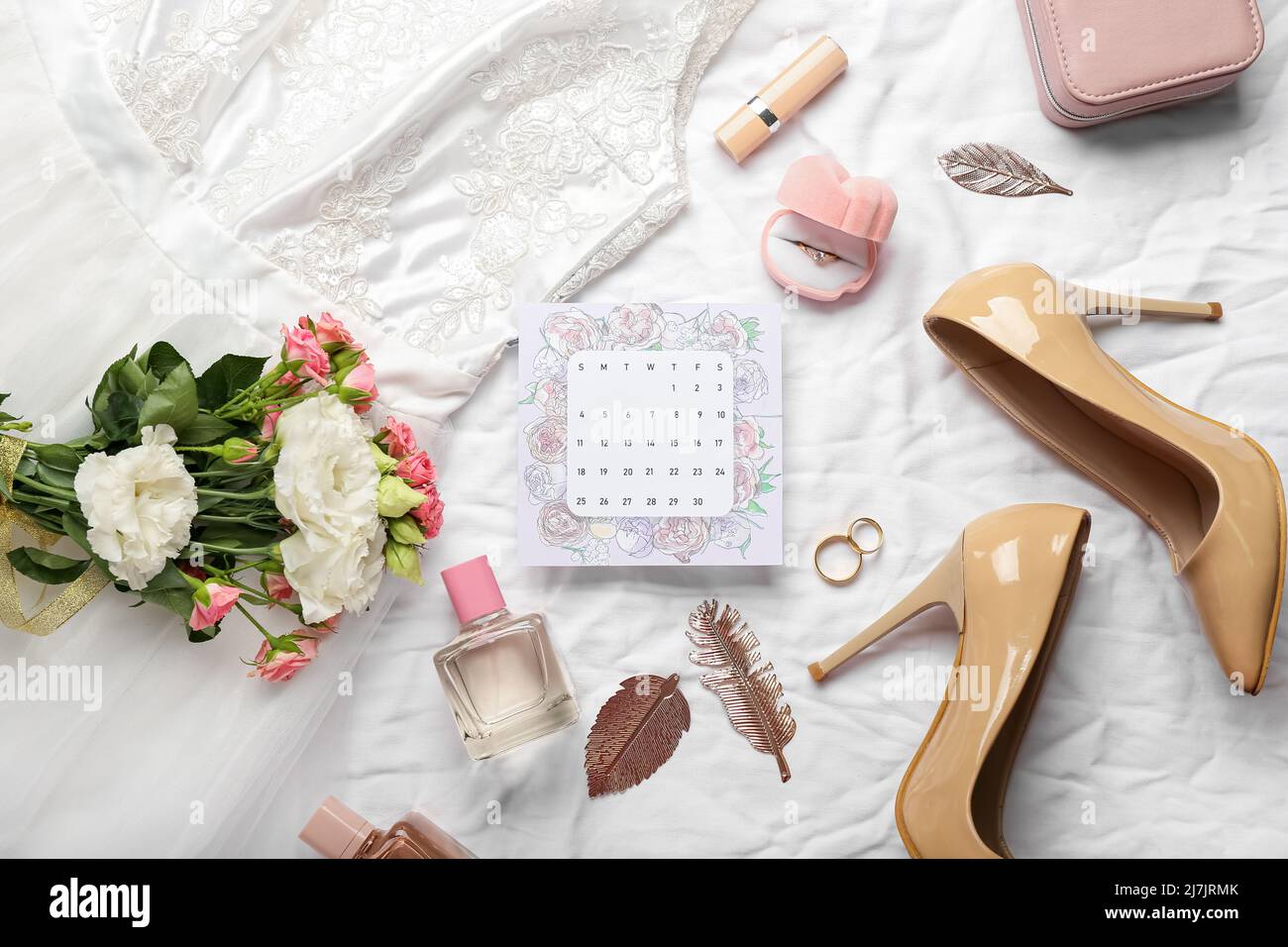 Wedding calendar, bouquet of flowers and bridal accessories on fabric ...