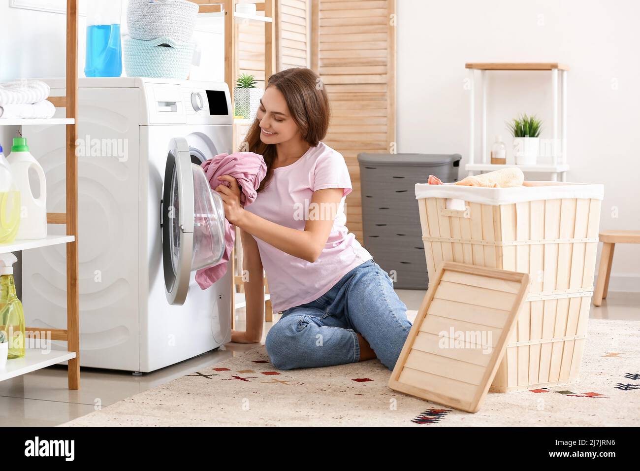 Beautiful housewife putting dirty laundry in washing machine at home Stock Photo - Alamy