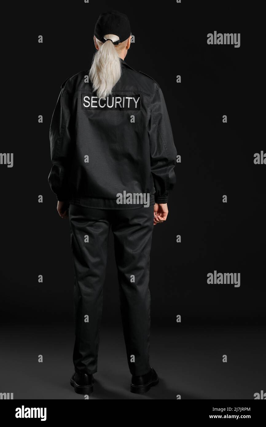 Female security guard on dark background, back view Stock Photo - Alamy
