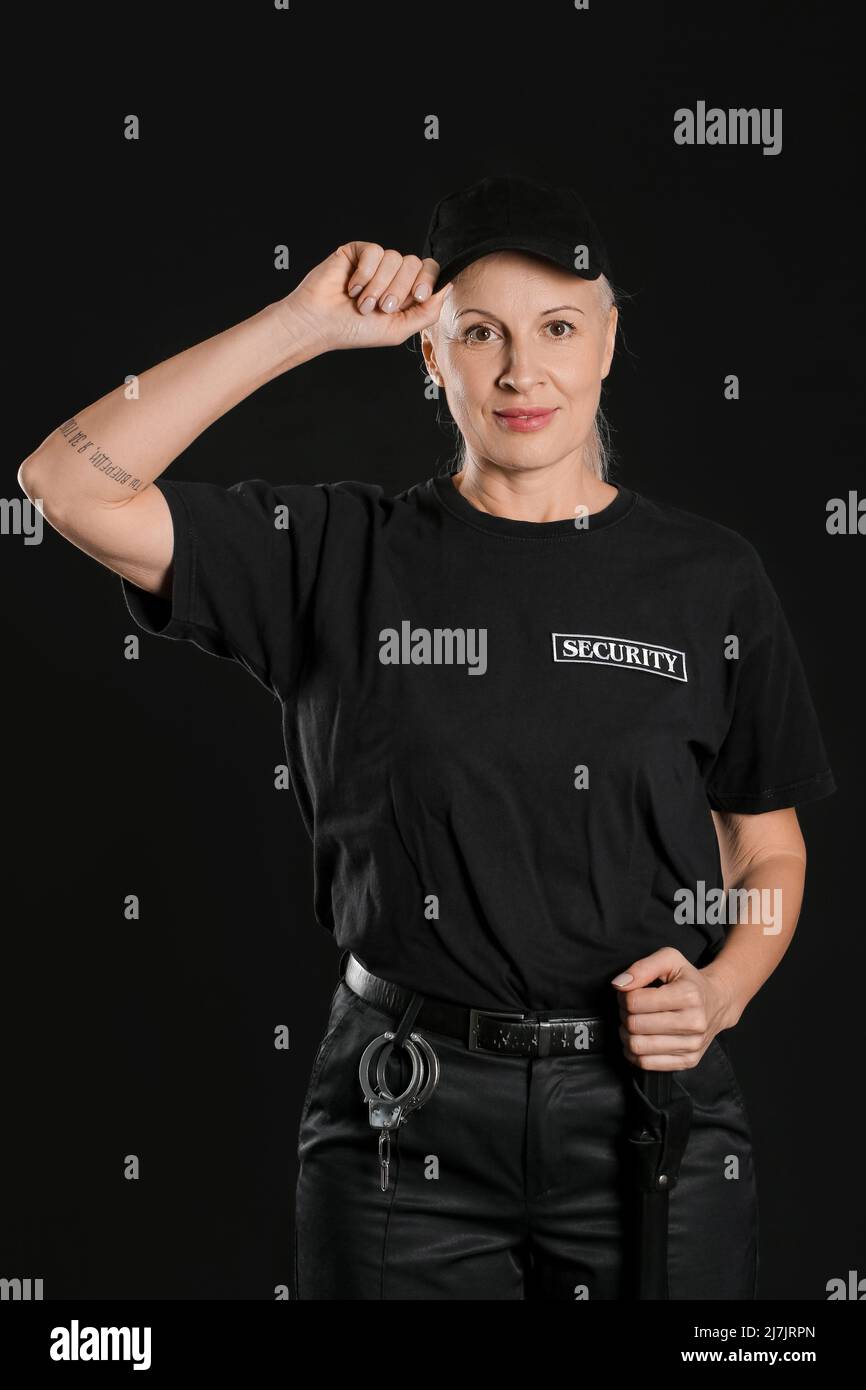 Female security guard on dark background Stock Photo - Alamy