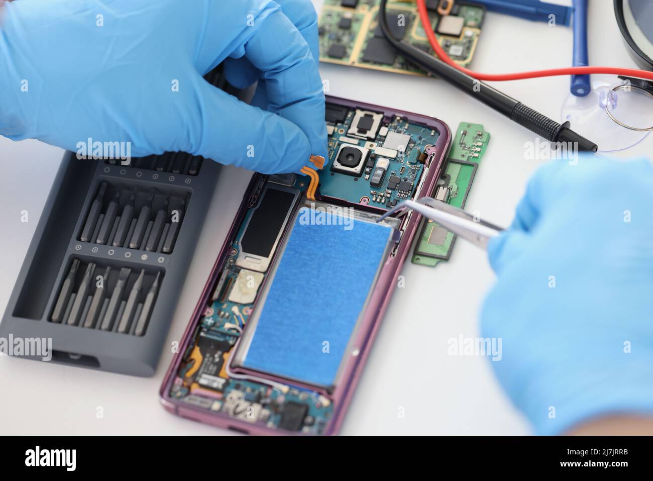 Technician fixing broken mobile phone, set new battery and cover ...