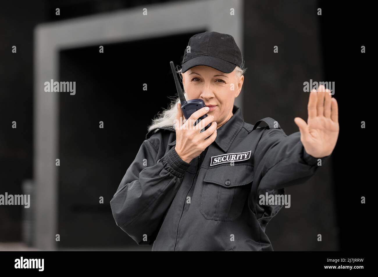 Female security guard showing stop gesture outdoors Stock Photo - Alamy