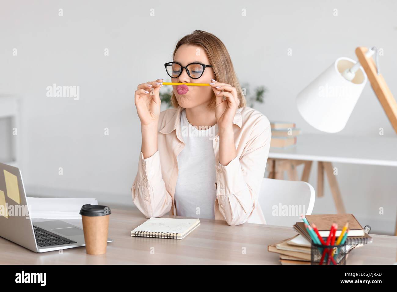 Female student having fun while studying in library Stock Photo - Alamy