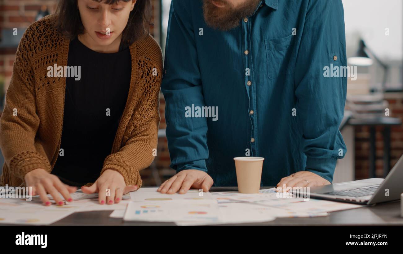 Man and woman brainstorming ideas and looking at rate charts to design ...