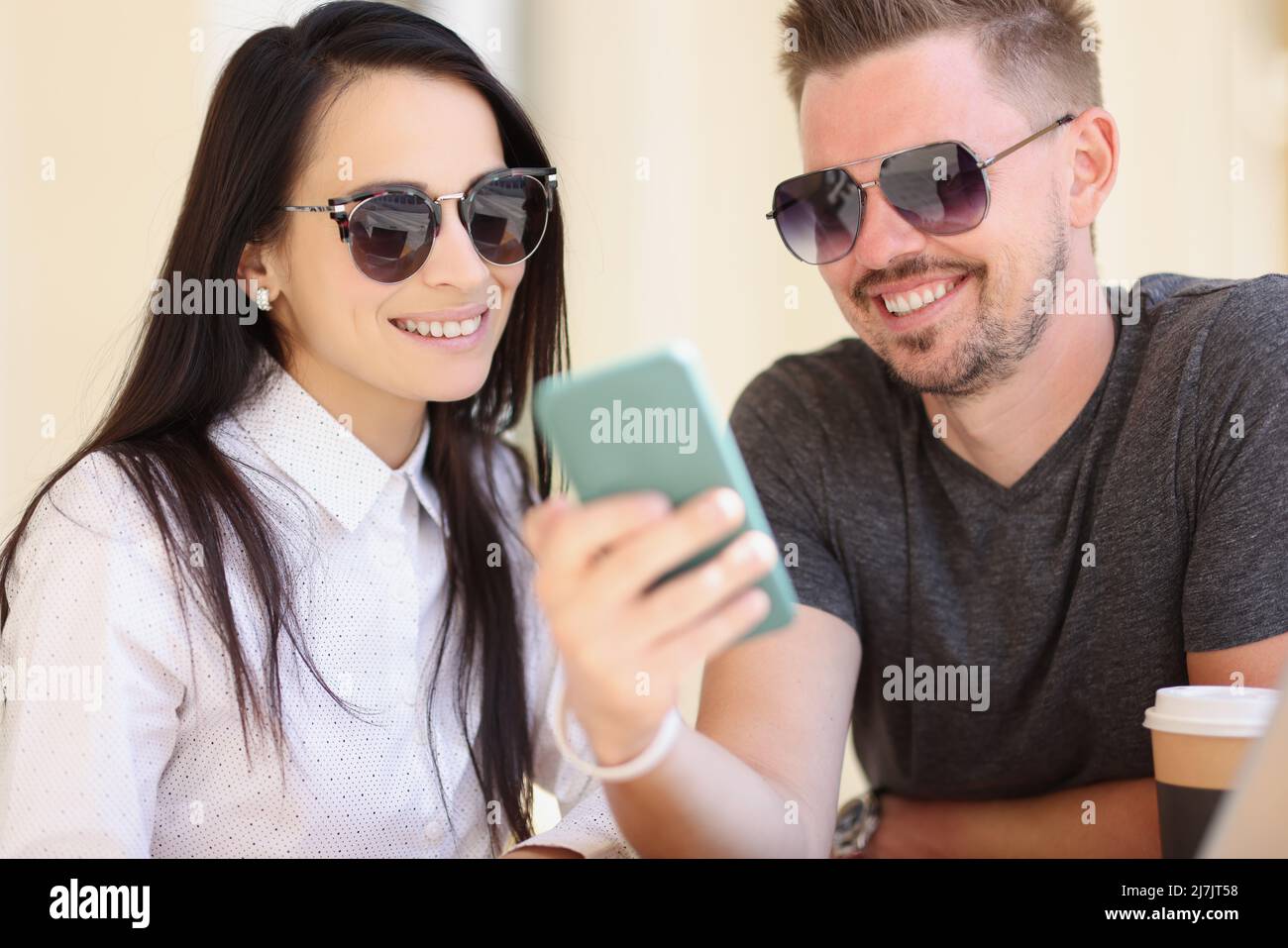 Couple watch memorable pictures on smartphone, go through pics from ...