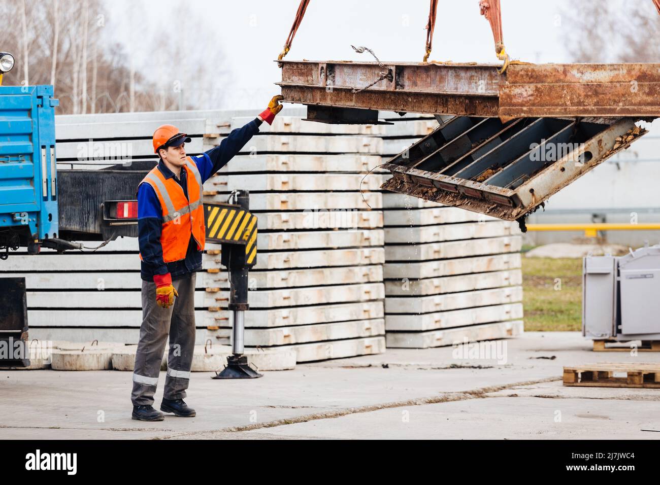 Slinger in helmet and vest controls unloading of metal structures on ...