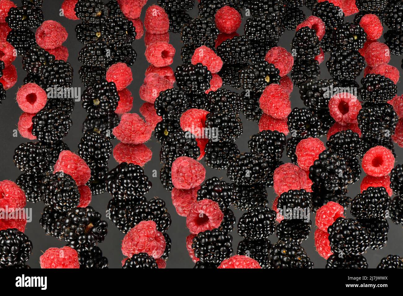 Raspberry and blackberry on black mirror. Side view. High resolution ...