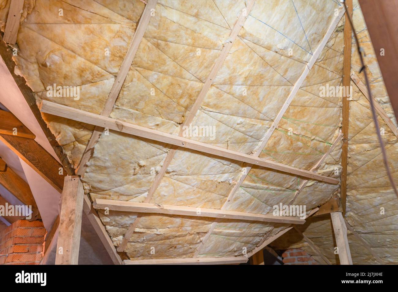 Laying sheet glass wool between roof rafters. Technology and process of ...