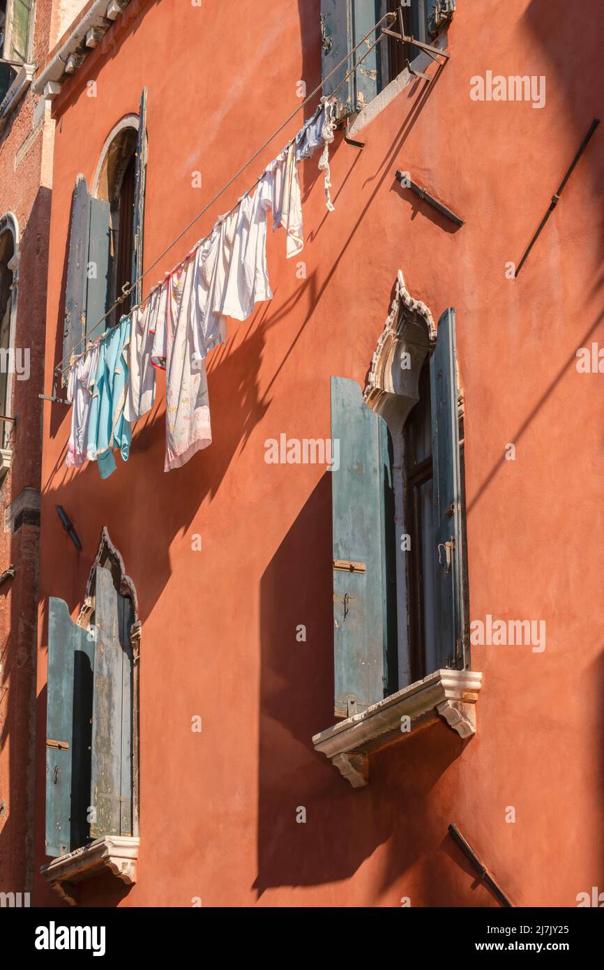 drying clothes hanged under traditional shuttered windows in Venice old ...
