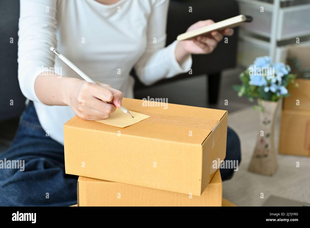 Female SME business startup online shop owner preparing her delivery ...
