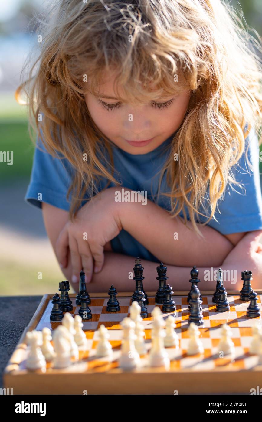 Close up face of clever smart child. Chess strategy. Kid playing chess ...