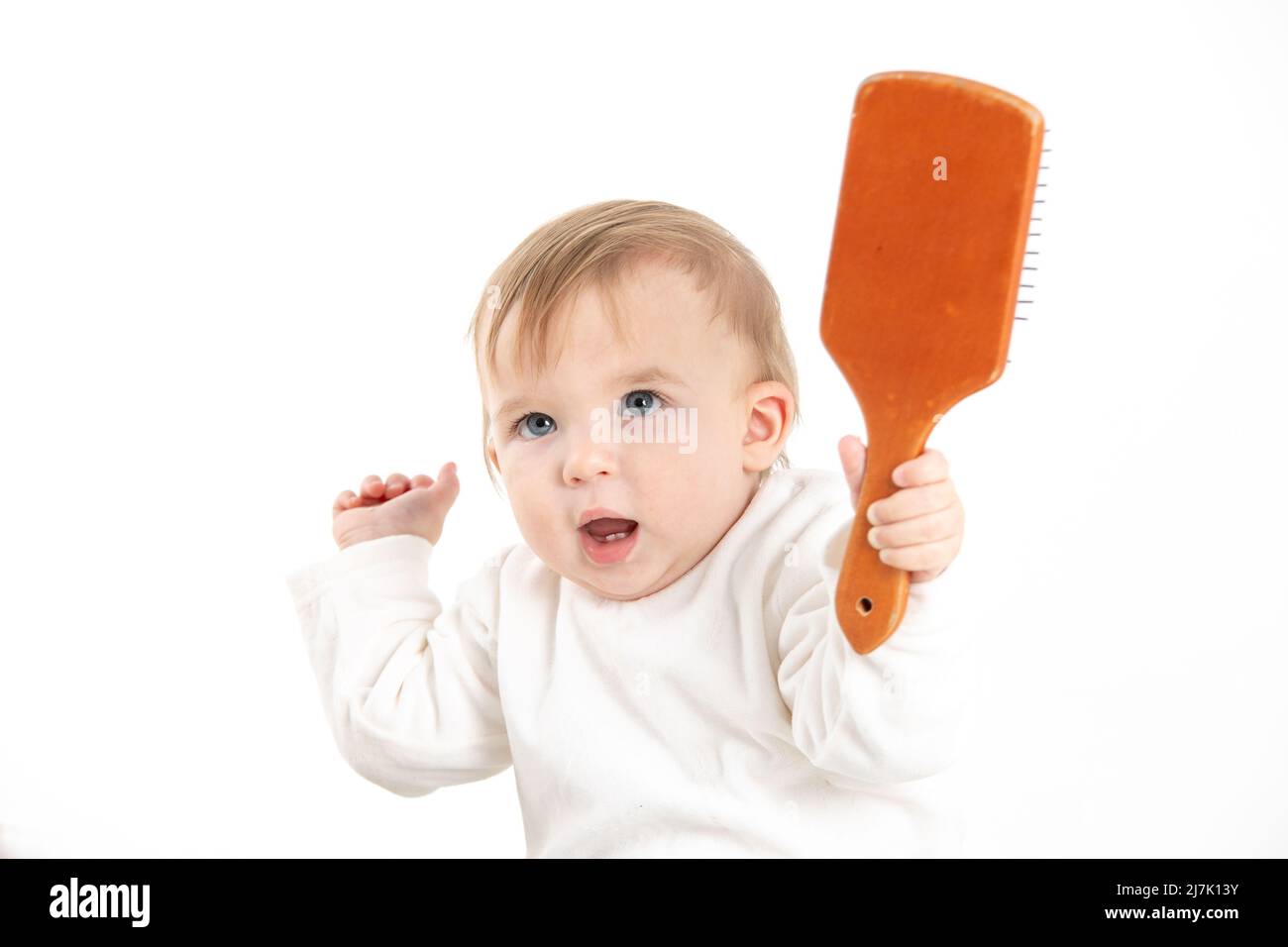 Stock studio photo with a white background of a baby with a comb in his ...