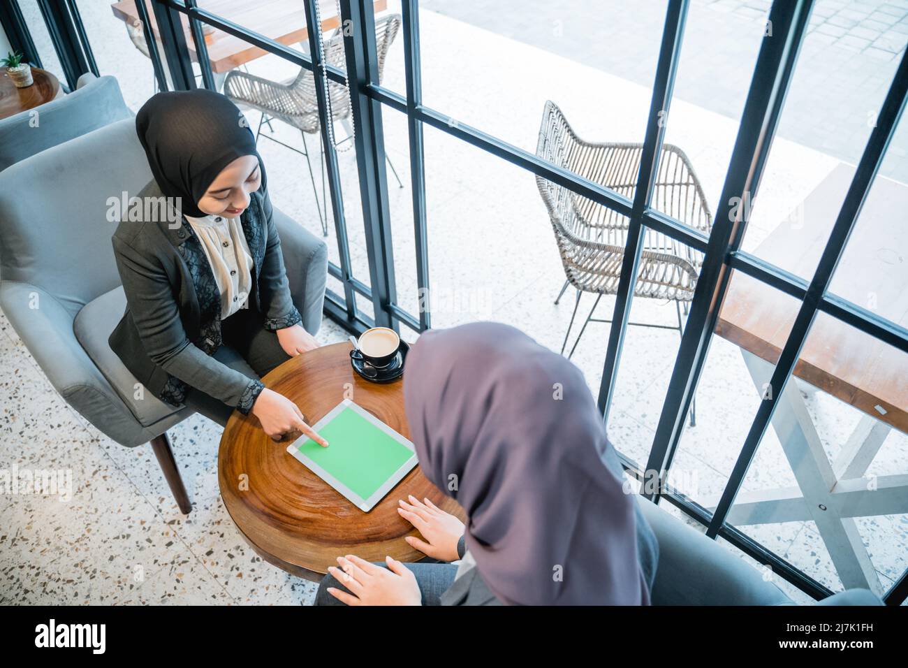 muslim female worker discussing with her colleague using tablet Stock ...
