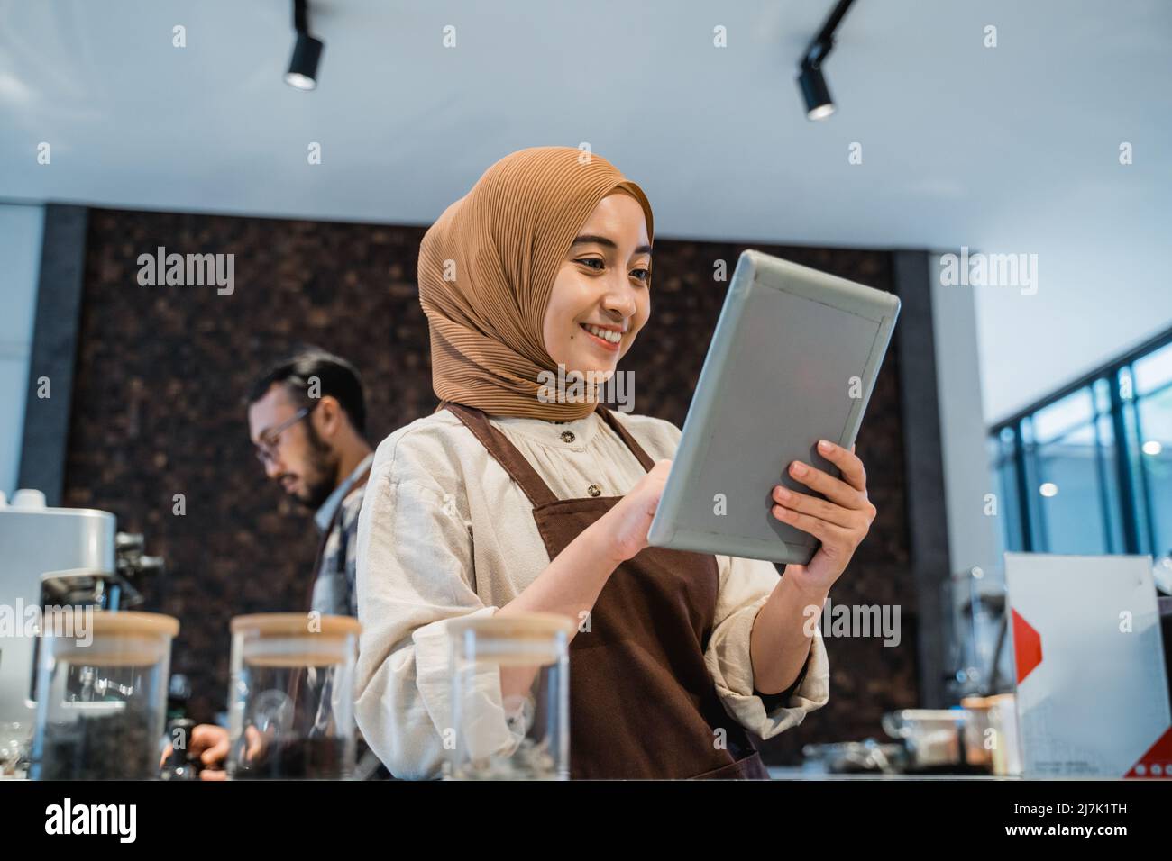 muslim female Cafe owner use tablet while working Stock Photo - Alamy