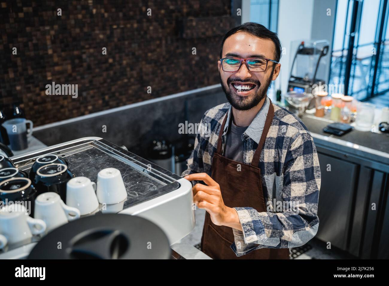 happy male Barista makes coffee with a coffee maker Stock Photo - Alamy