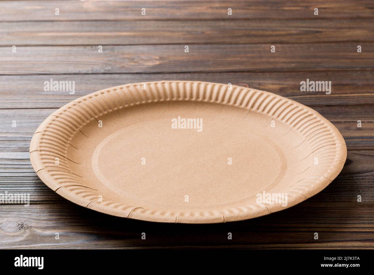 Perspective view of eco paper plate on wooden background. Empty space ...