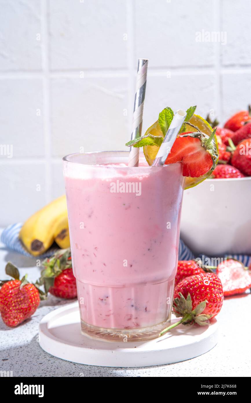 On glass with Strawberry banana milkshake, with fresh fruits on white ...