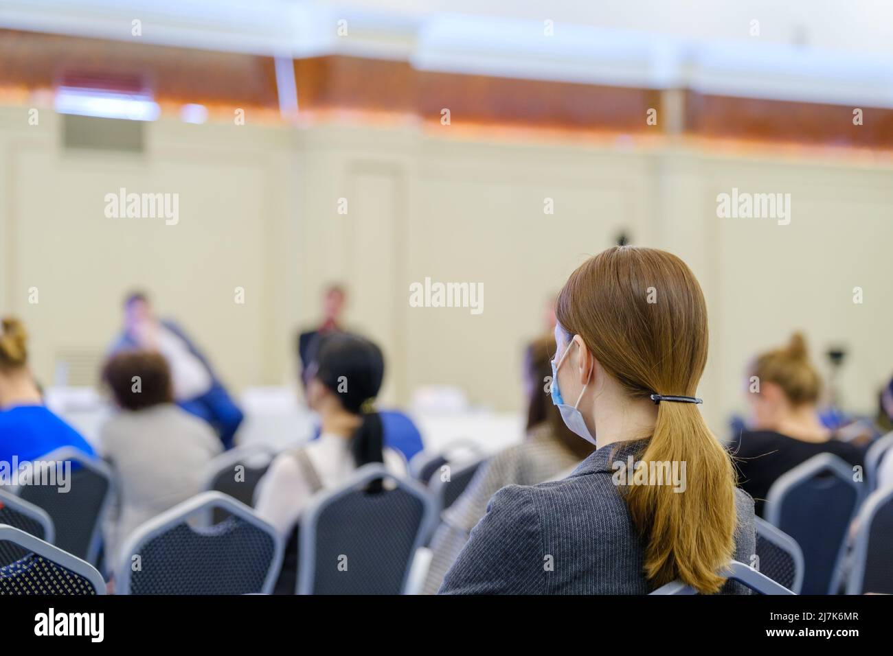 Woman watching presentation during seminar Stock Photo - Alamy