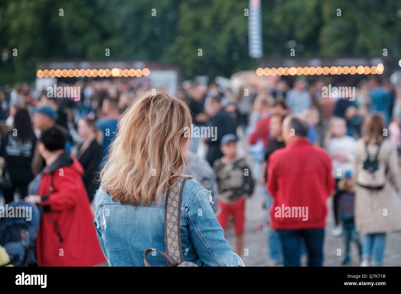 Woman walking in crowded park Stock Photo - Alamy