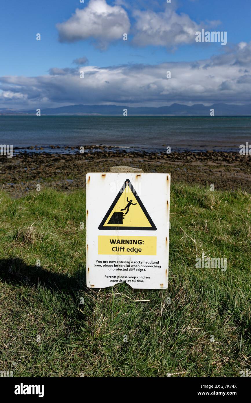 Yellow and white Danger cliff edge warning sign on wales coast path ...