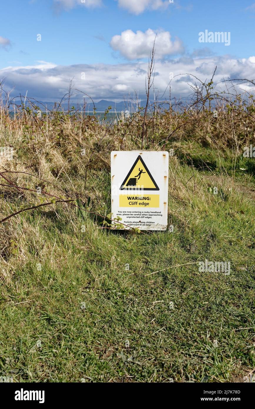 Yellow and white Danger cliff edge warning sign on wales coast path ...