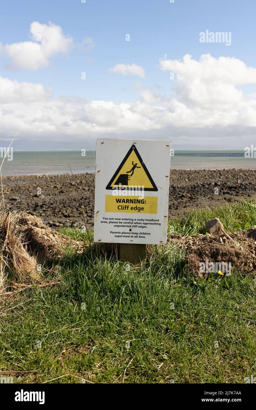 Yellow and white Danger cliff edge warning sign on wales coast path ...
