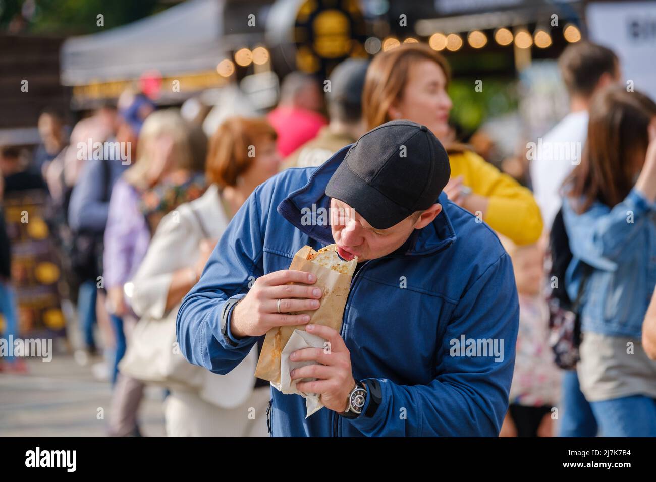 Man eating fast food on street Stock Photo - Alamy