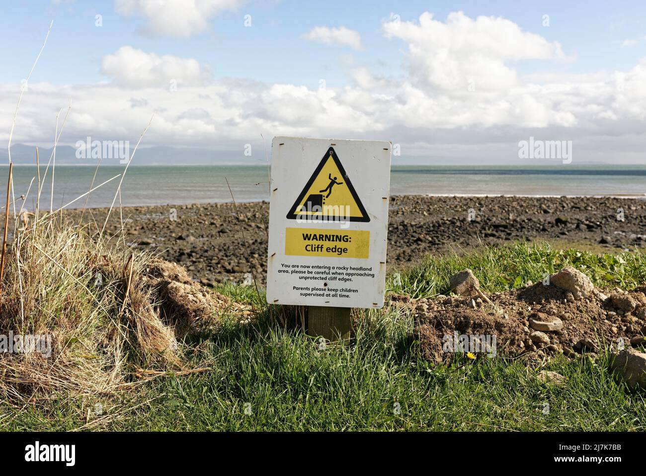 Yellow and white Danger cliff edge warning sign on wales coast path ...