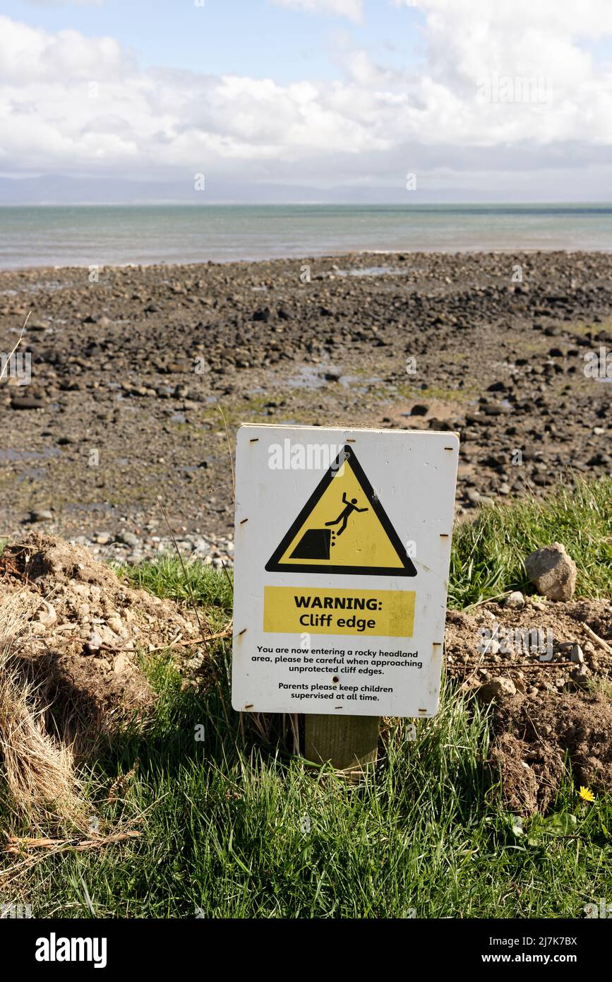 Yellow and white Danger cliff edge warning sign on wales coast path ...
