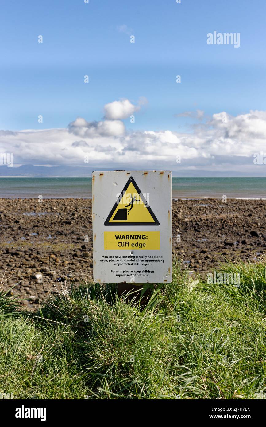Yellow and white Danger cliff edge warning sign on wales coast path ...