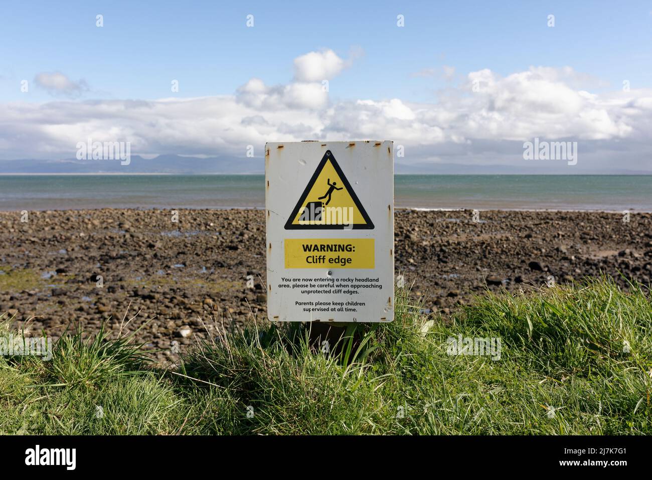 Yellow and white Danger cliff edge warning sign on wales coast path ...
