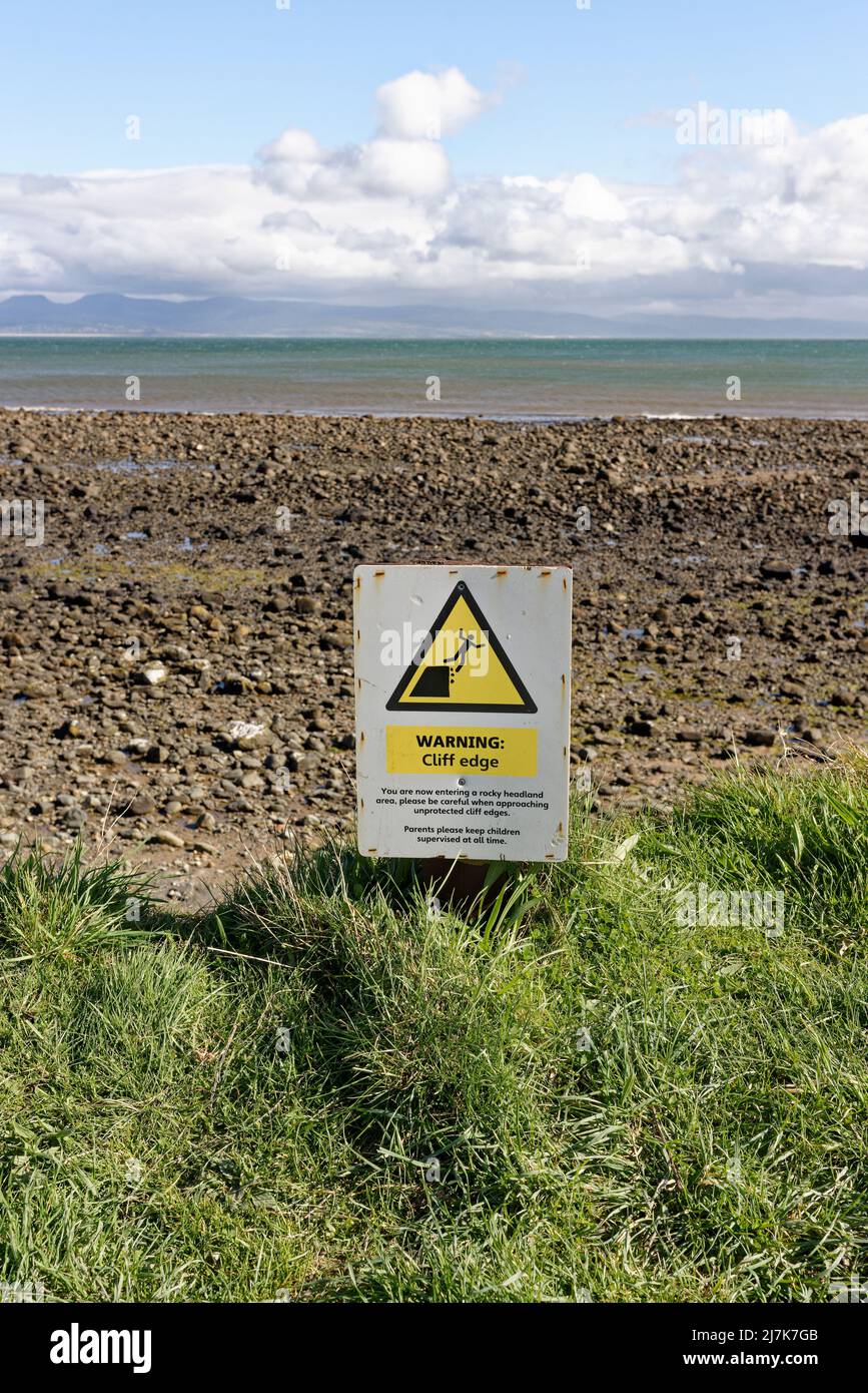 Yellow and white Danger cliff edge warning sign on wales coast path ...