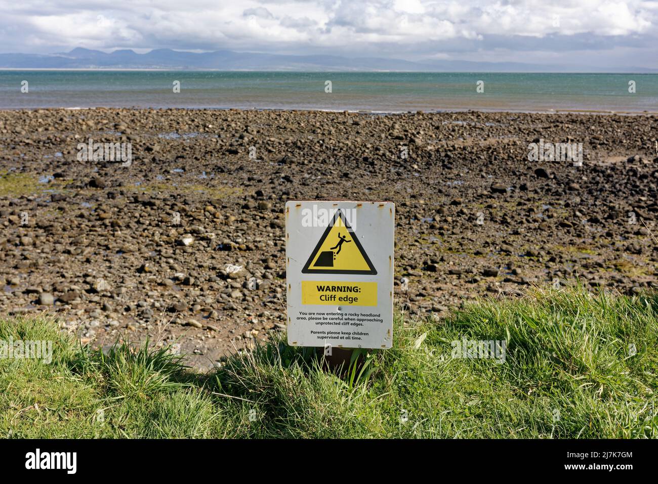 Yellow and white Danger cliff edge warning sign on wales coast path ...