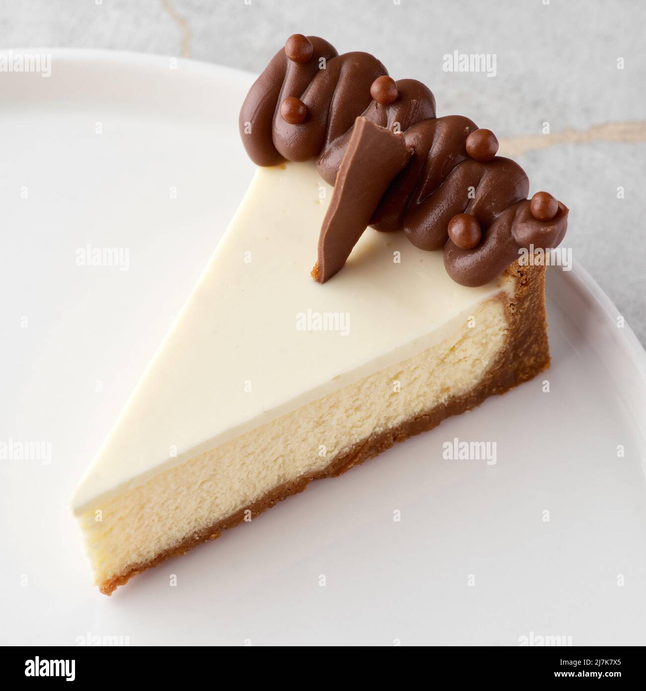 Cheesecake slice with melted and crushed chocolate, serving slices on a ...