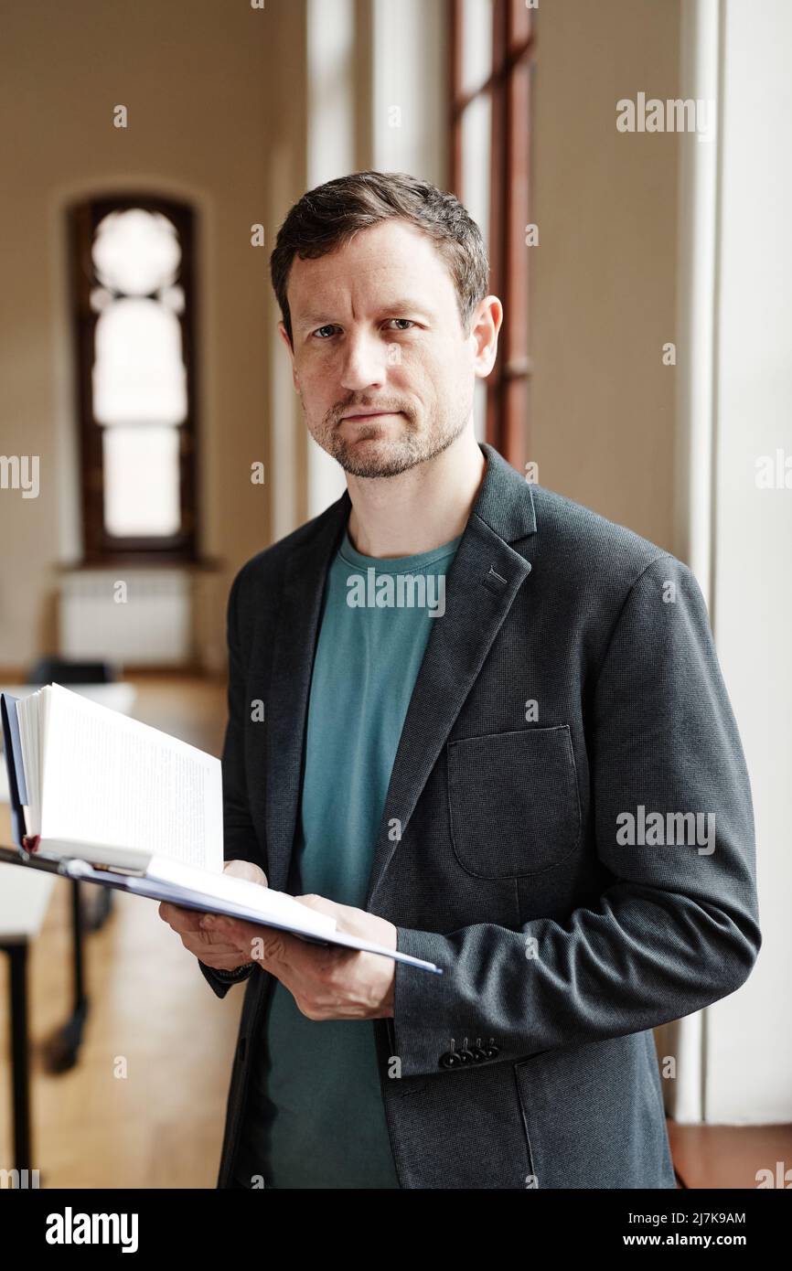 Warm toned vertical portrait of male college professor looking at ...
