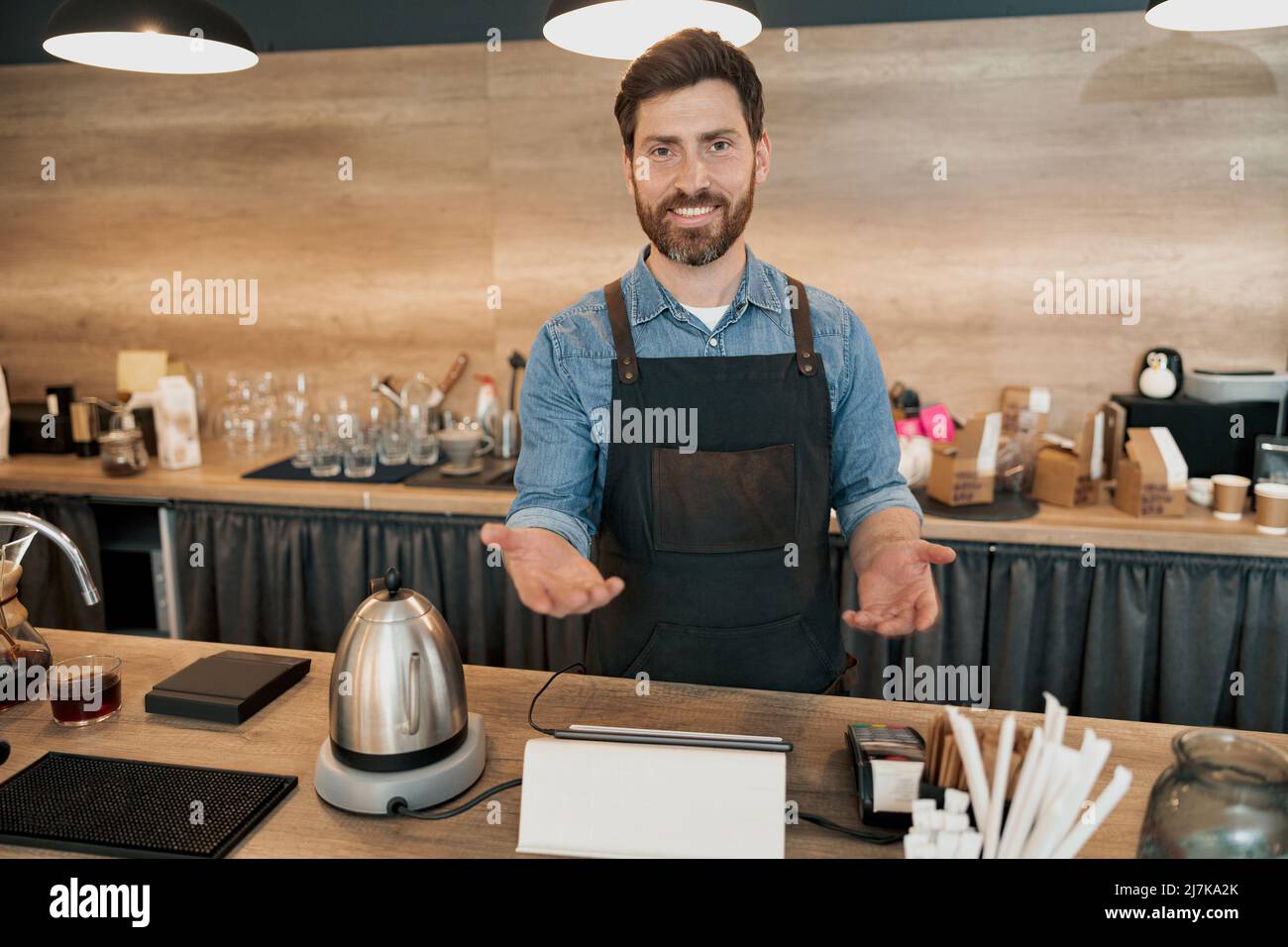 Barista joyfully greets a loyal customer while standing behind counter ...